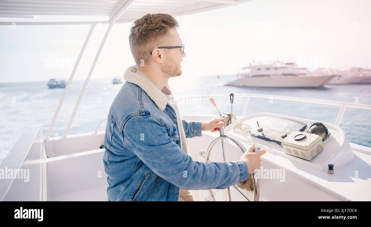 Concept rental or training driver man captain of white luxury yacht ...
