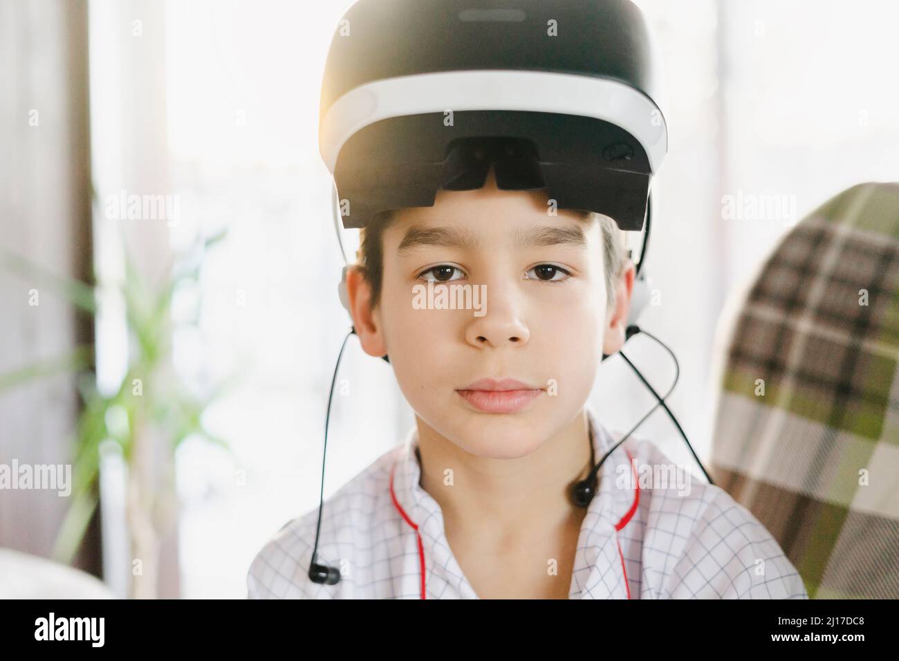 Boy wearing virtual reality simulator on forehead at home Stock Photo ...
