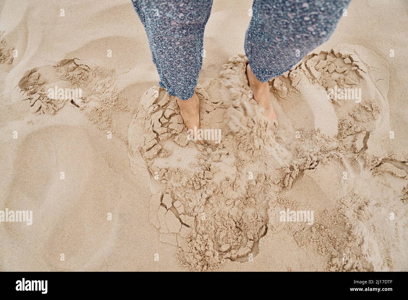 Woman standing on sand Stock Photo - Alamy