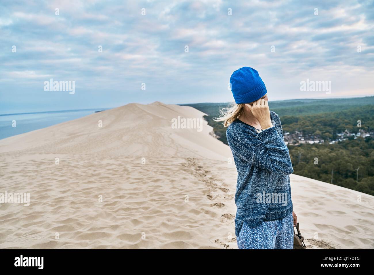 Tourist exploring sand dune on vacation Stock Photo - Alamy