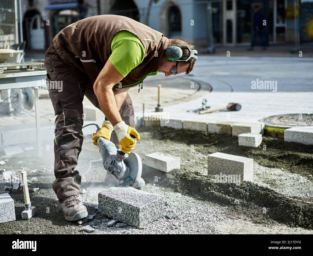 Construction worker cutting paving stone with electric saw Stock Photo ...
