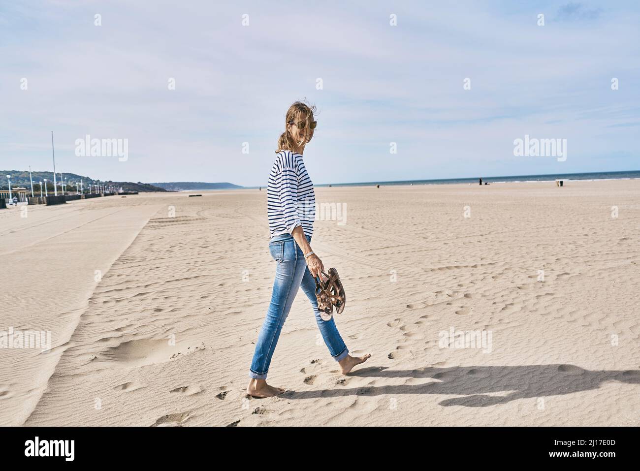 Tourist walking at beach on sunny day Stock Photo - Alamy