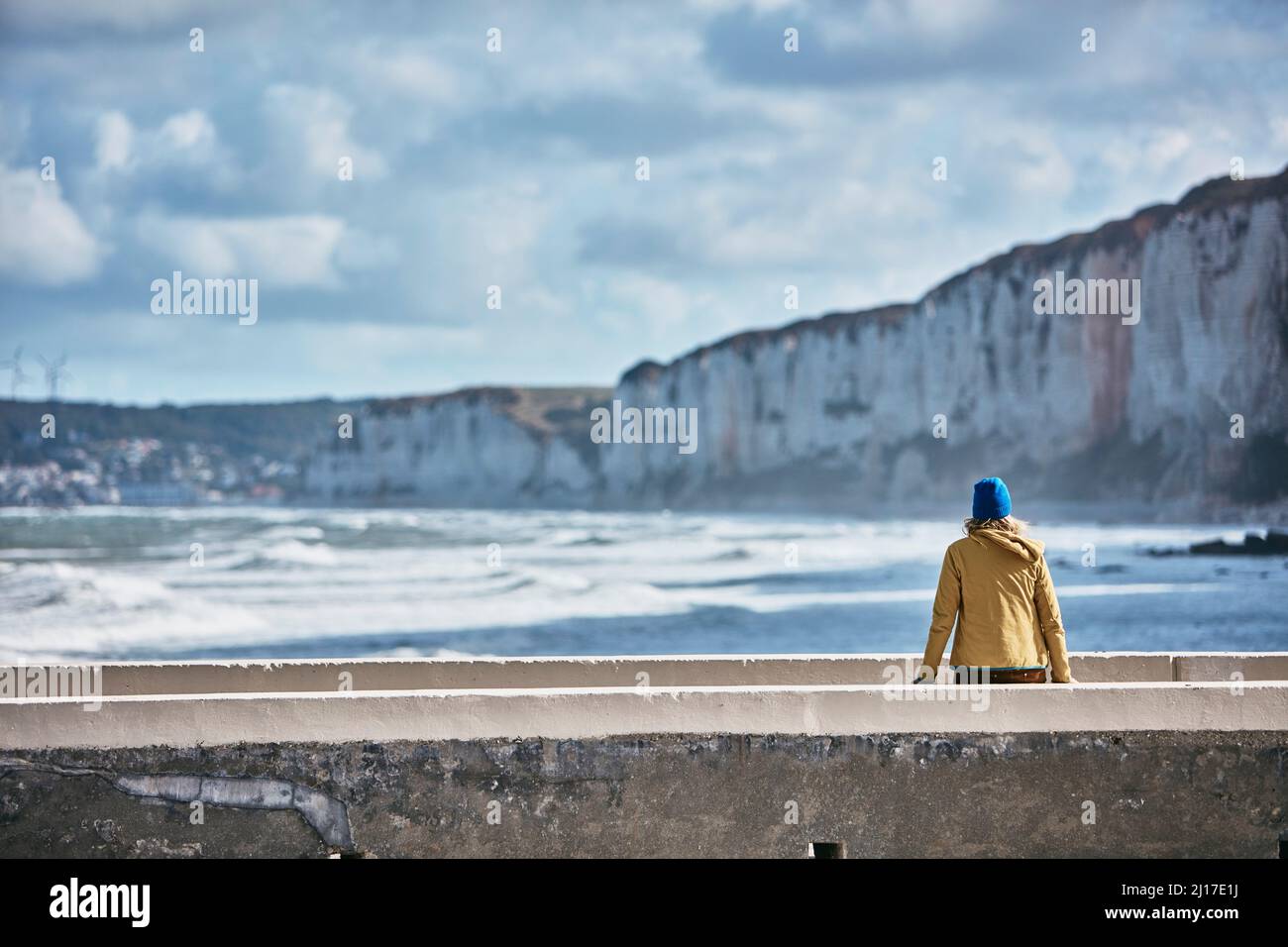 Tourist admiring sea sitting on wall at vacation Stock Photo - Alamy
