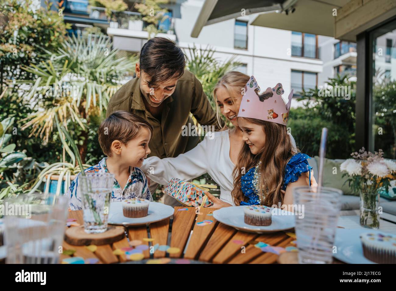 Happy parents talking with children on birthday party at back yard ...