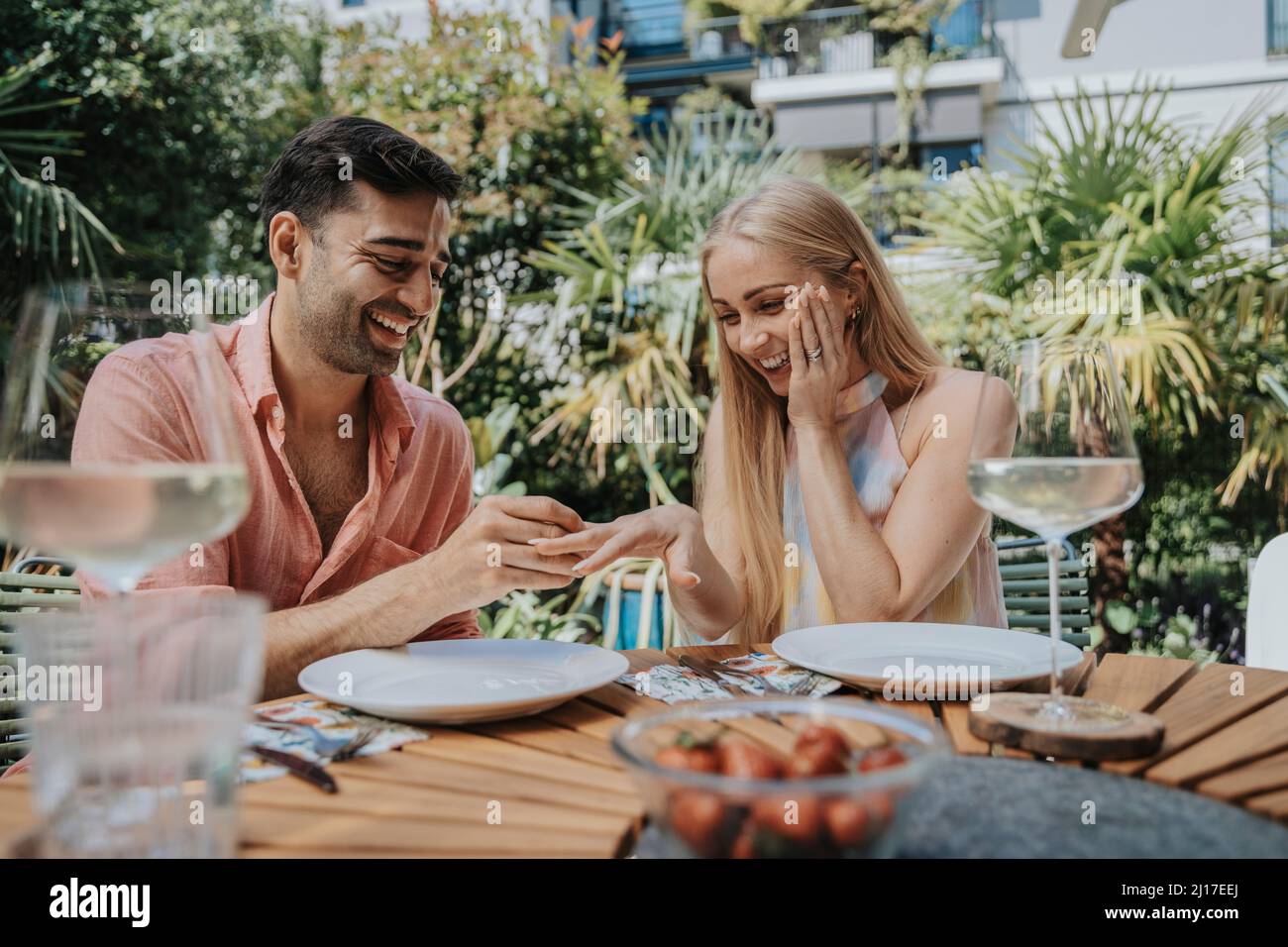 Man proposing woman with ring at outdoor table Stock Photo - Alamy