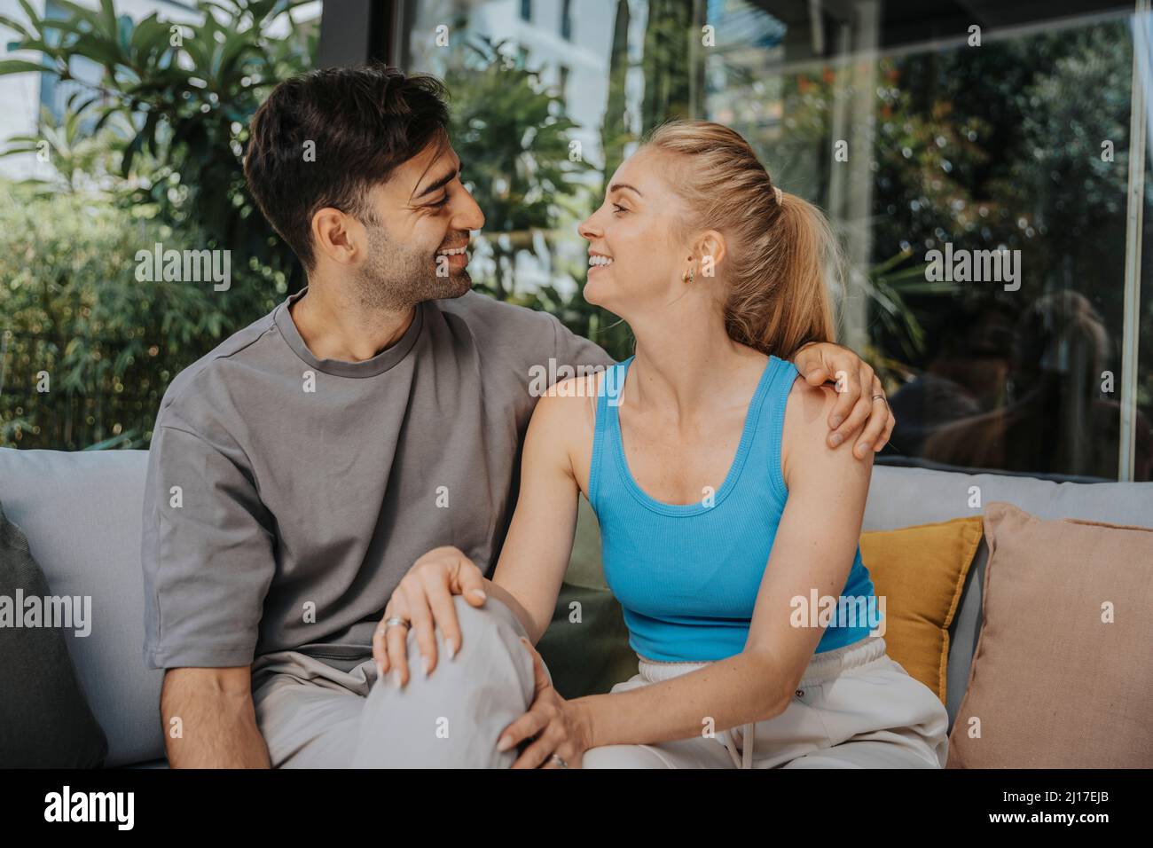 Happy couple talking at patio Stock Photo - Alamy