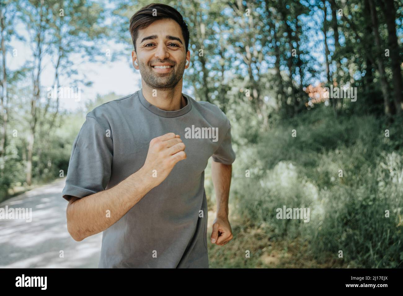 Happy man running and listening music through bluetooth earphones Stock ...