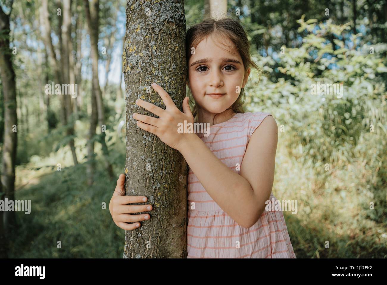 Innocent girl embracing tree in nature Stock Photo - Alamy
