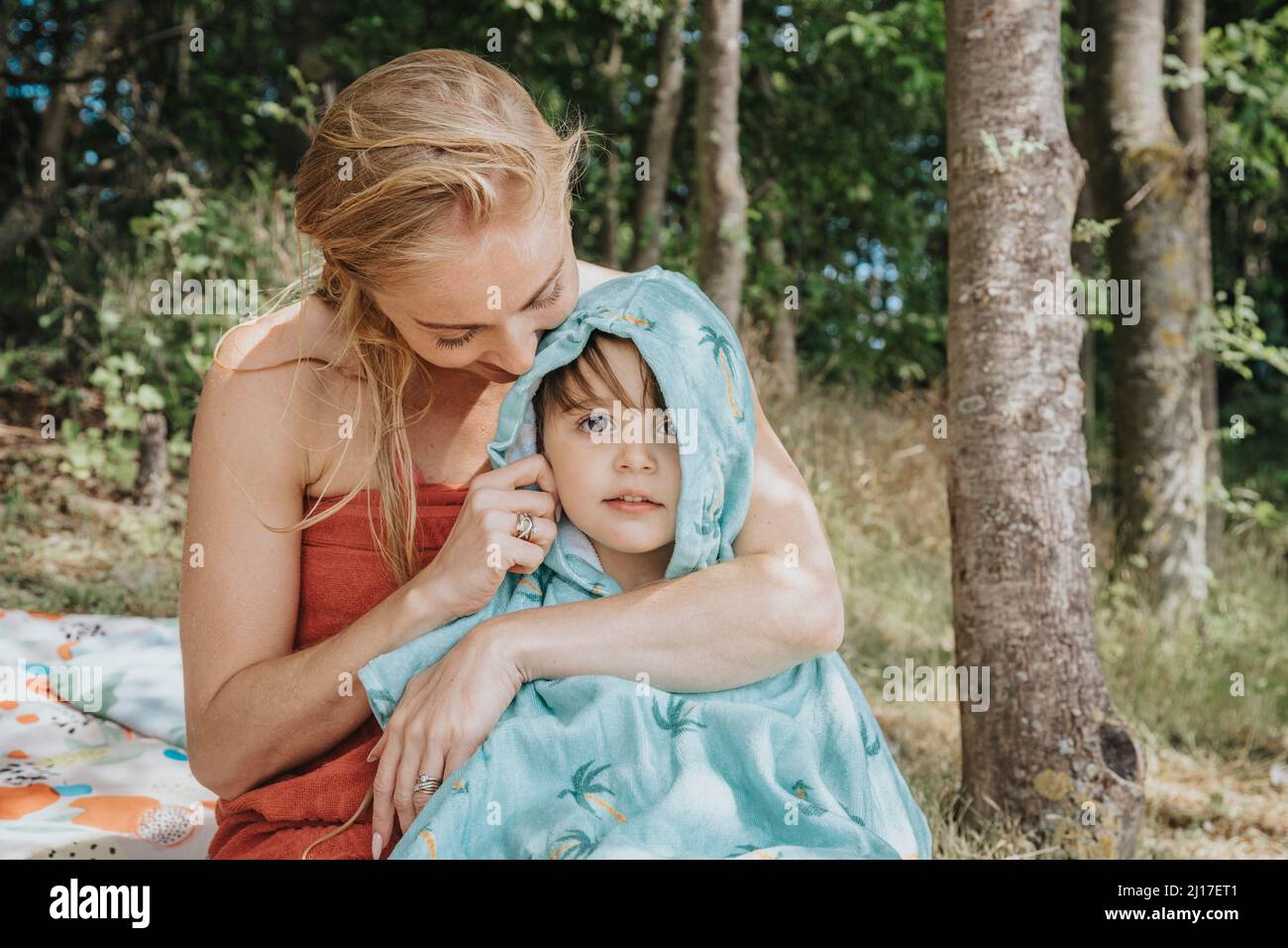 Mother drying son with towel at lakeshore Stock Photo - Alamy