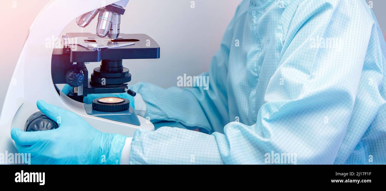 Banner microscope with metal lens at laboratory with hand of ...