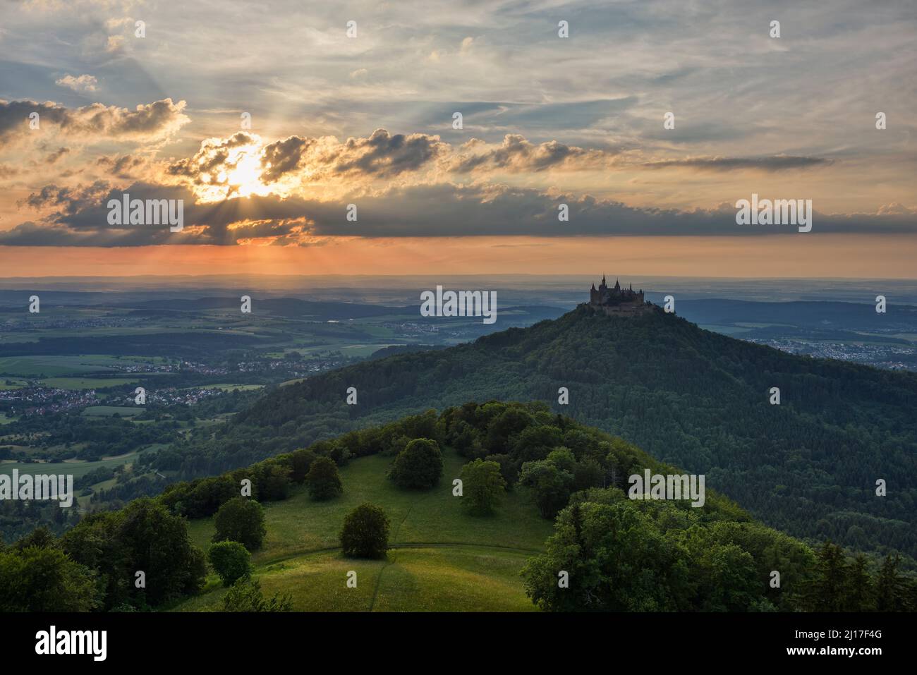 Germany, Baden-Wurttemberg, Hechingen, View of forested Hohenzollern mountain at summer sunset ...