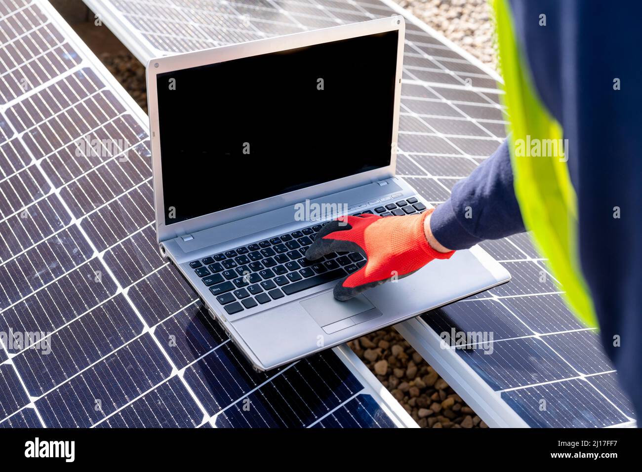 Technician working on laptop over solar panels Stock Photo - Alamy