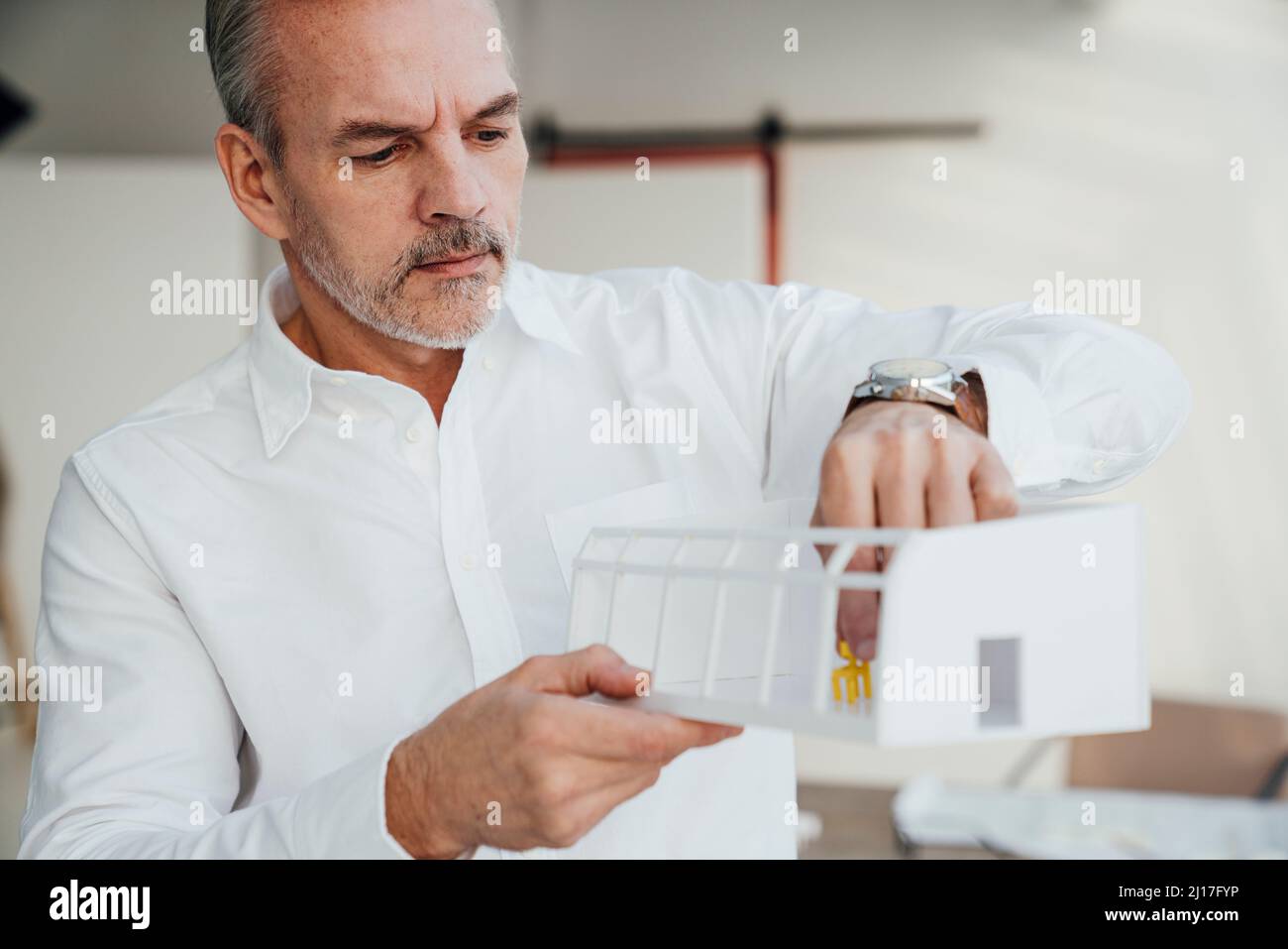Architect examining architectural model at work place Stock Photo - Alamy