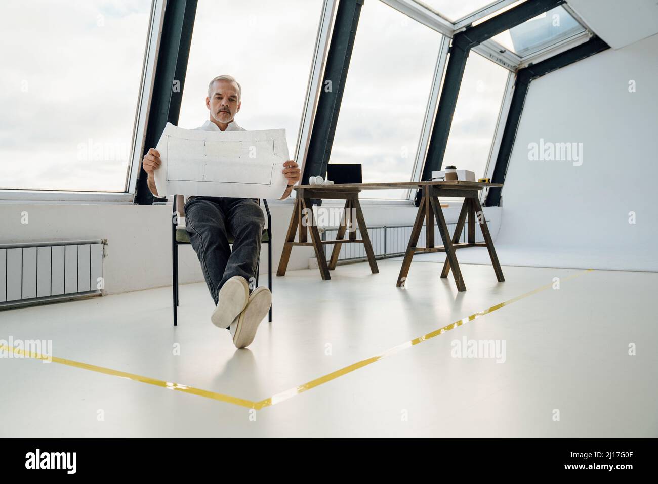 Businessman examining paper document sitting at work place Stock Photo ...