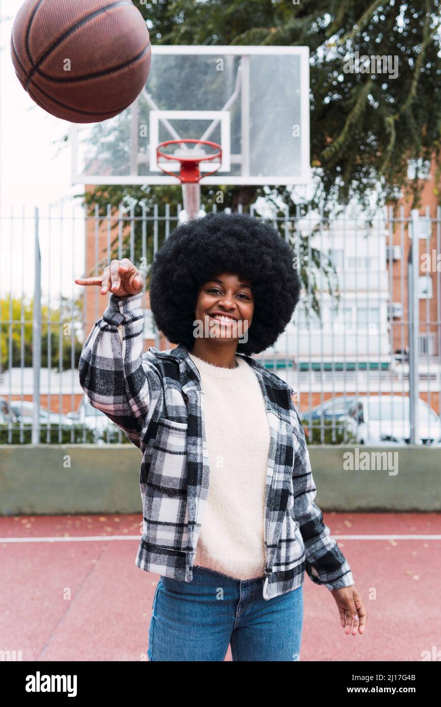 Young woman throwing basketball standing on sports court Stock Photo ...