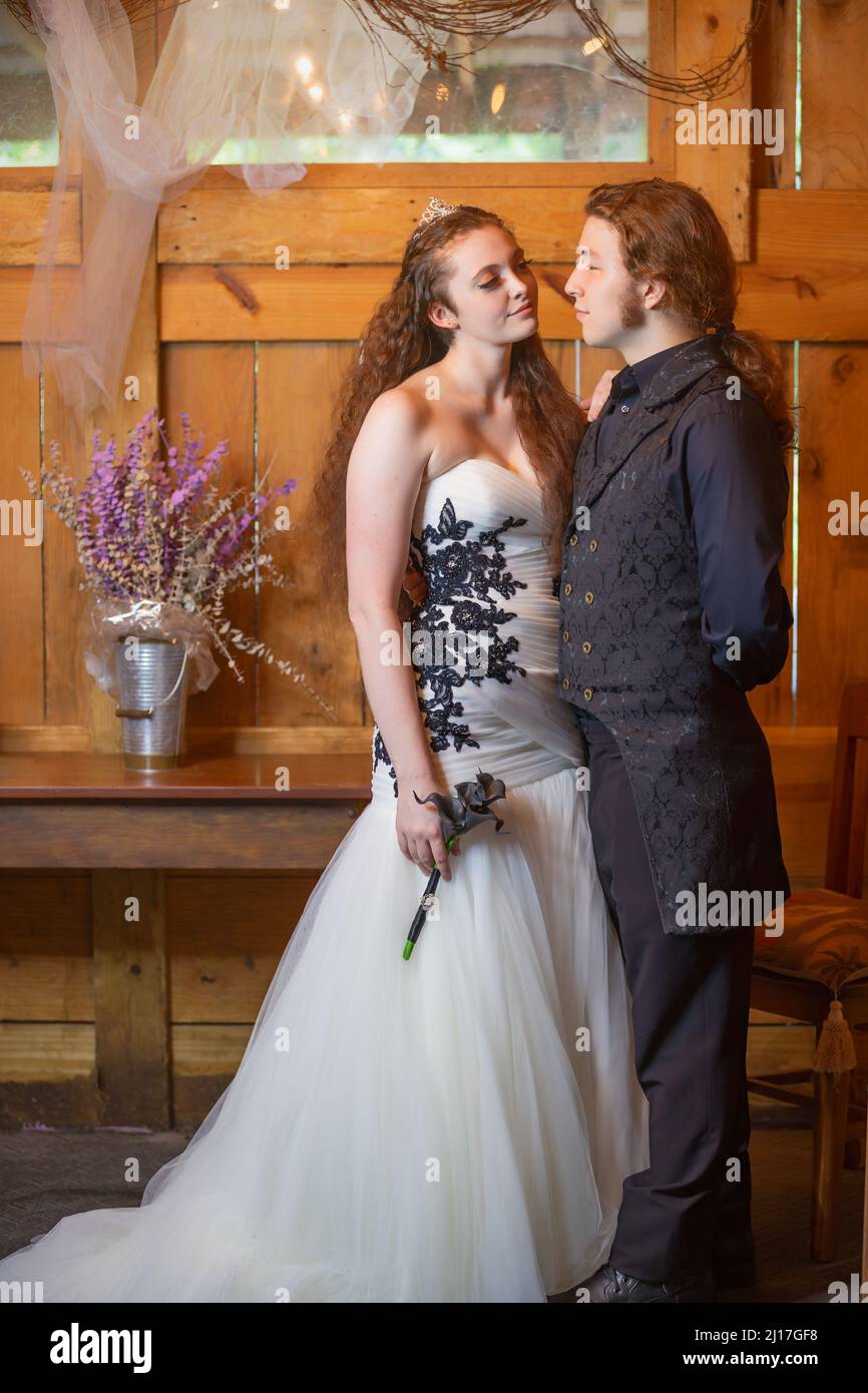 A young couple pose for a mock wedding shoot in a horse barn Stock ...