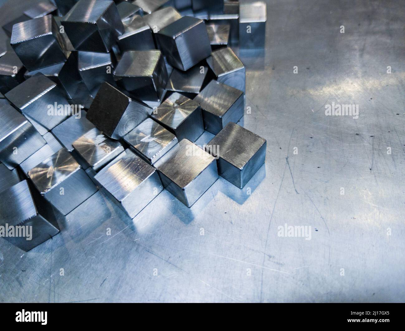 pile of small machined shiny steel cubes on metal surface Stock Photo ...