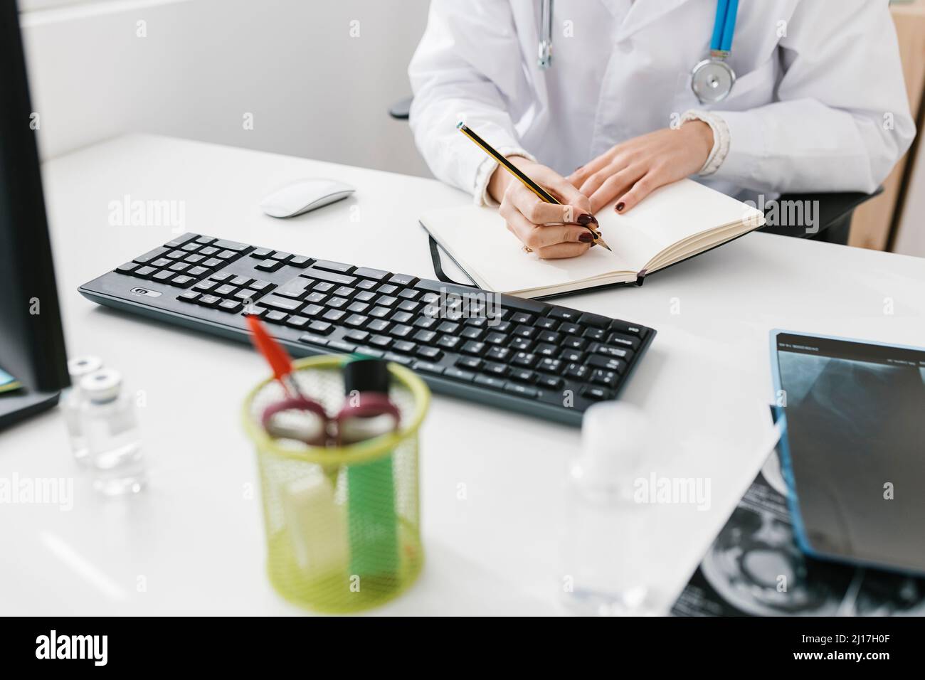 Doctor writing notes in diary sitting at medical clinic Stock Photo - Alamy