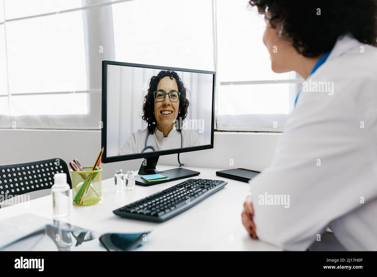 Doctor on video call with colleague through desktop PC at clinic Stock ...