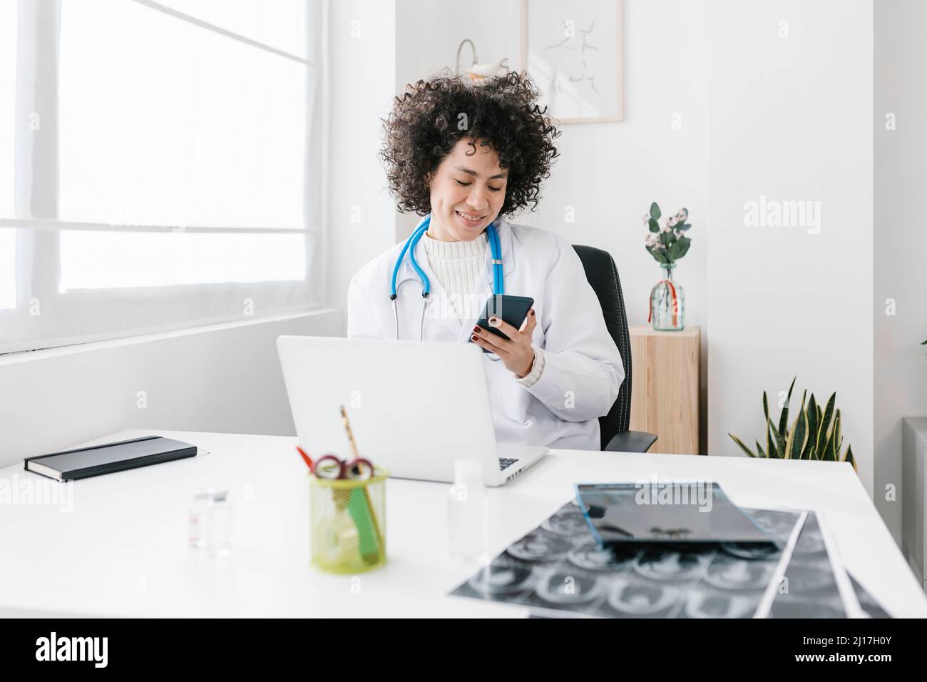 Smiling doctor texting mobile phone hi-res stock photography and images ...