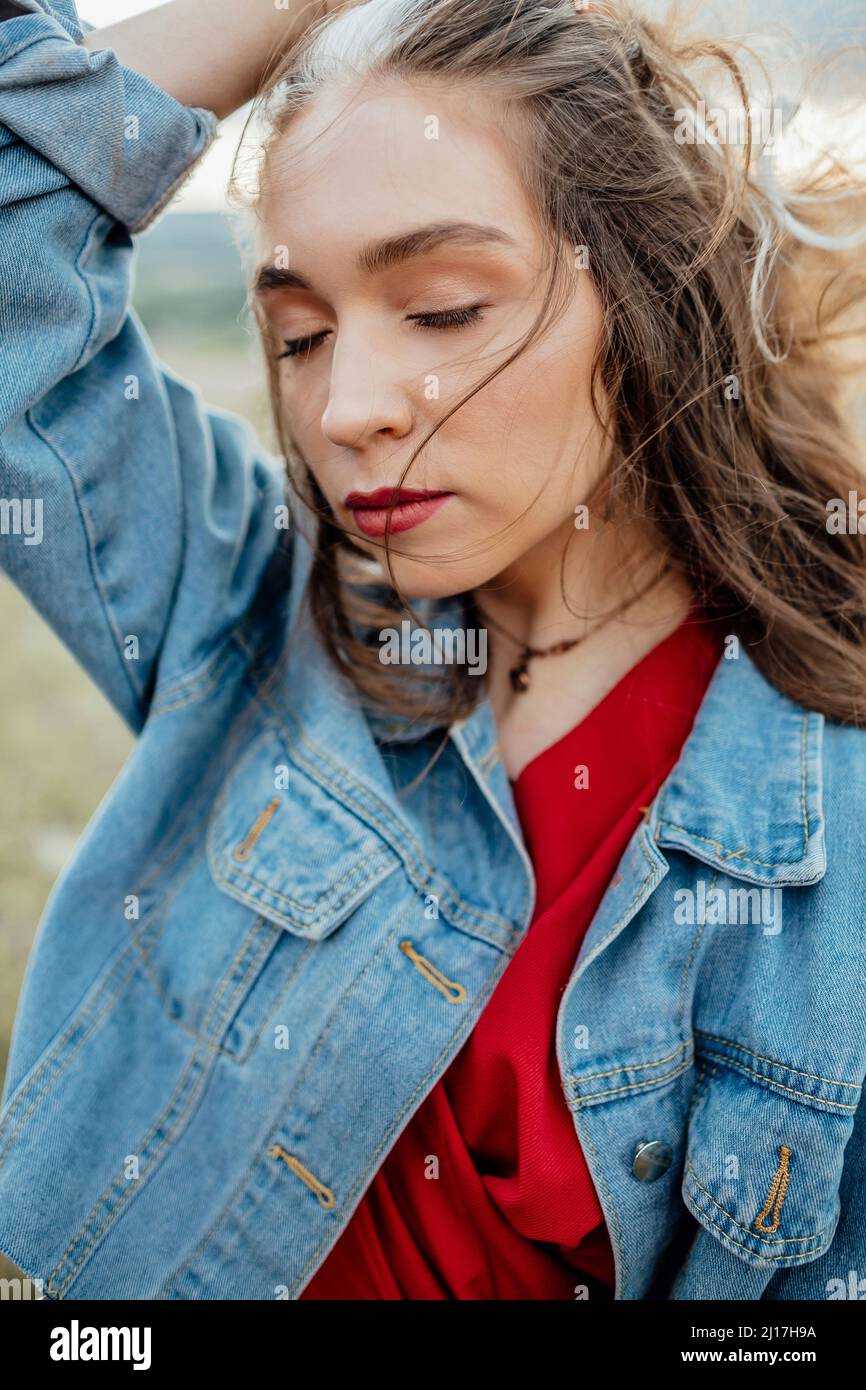 Young woman with eyes closed wearing denim jacket Stock Photo - Alamy