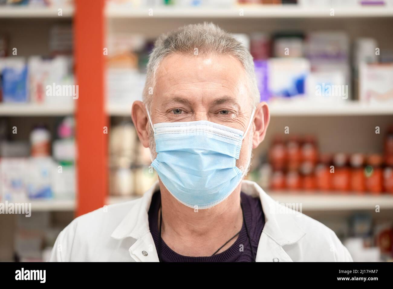 Pharmacist wearing protective face mask at pharmacy store in pandemic ...