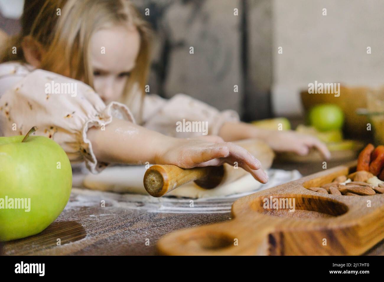 Girl using rolling pin in kitchen at home Stock Photo - Alamy
