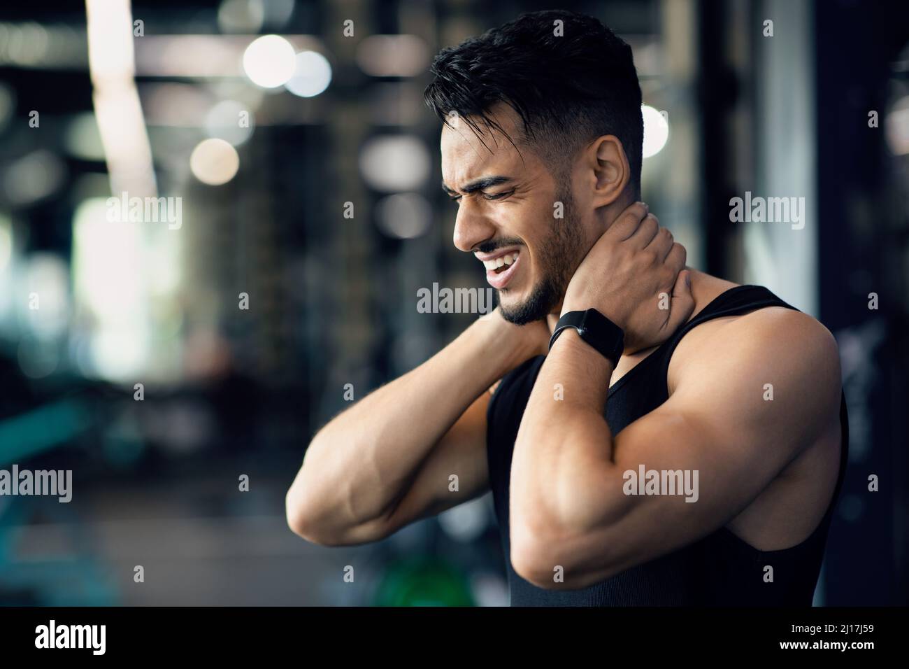 Body Injury. Portrait of young arab man suffering from pain in neck ...