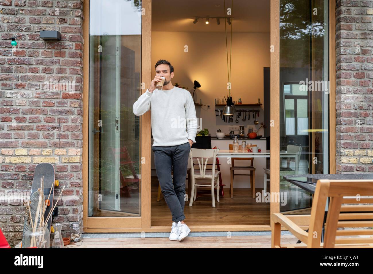 Man standing in doorway and drinking coffee hi-res stock photography ...