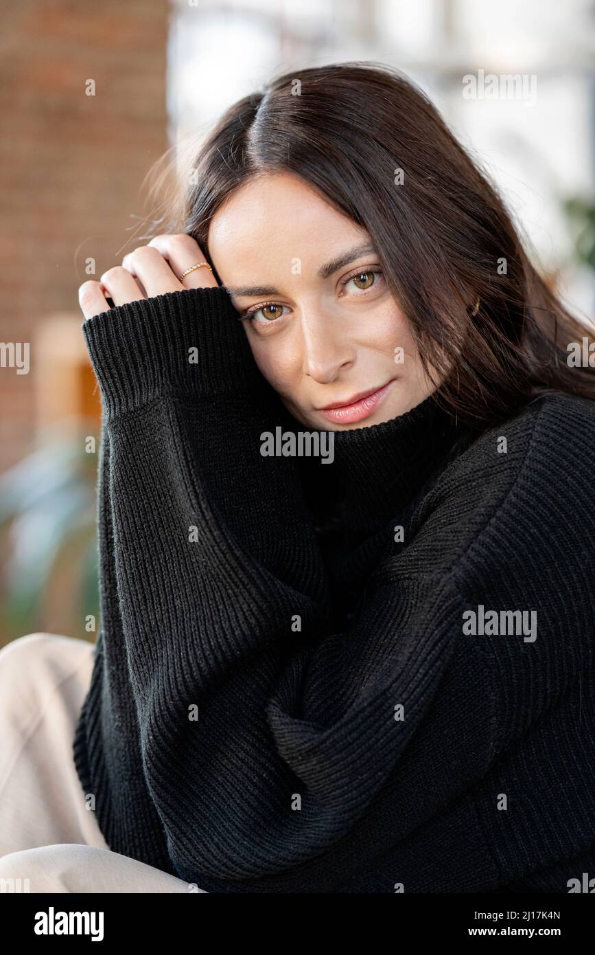 Beautiful woman wearing black sweater at home Stock Photo - Alamy