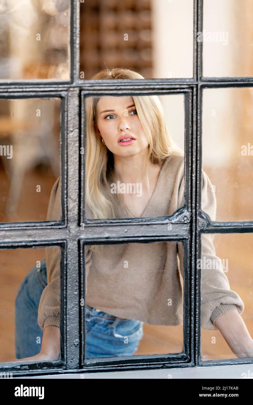 Beautiful blond woman seen through glass window Stock Photo - Alamy