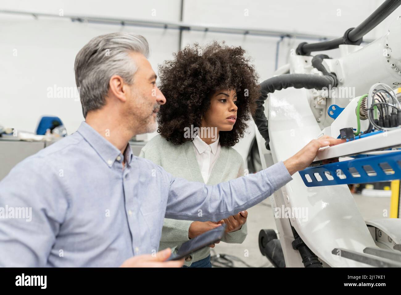 Engineers examining machinery in factory Stock Photo - Alamy