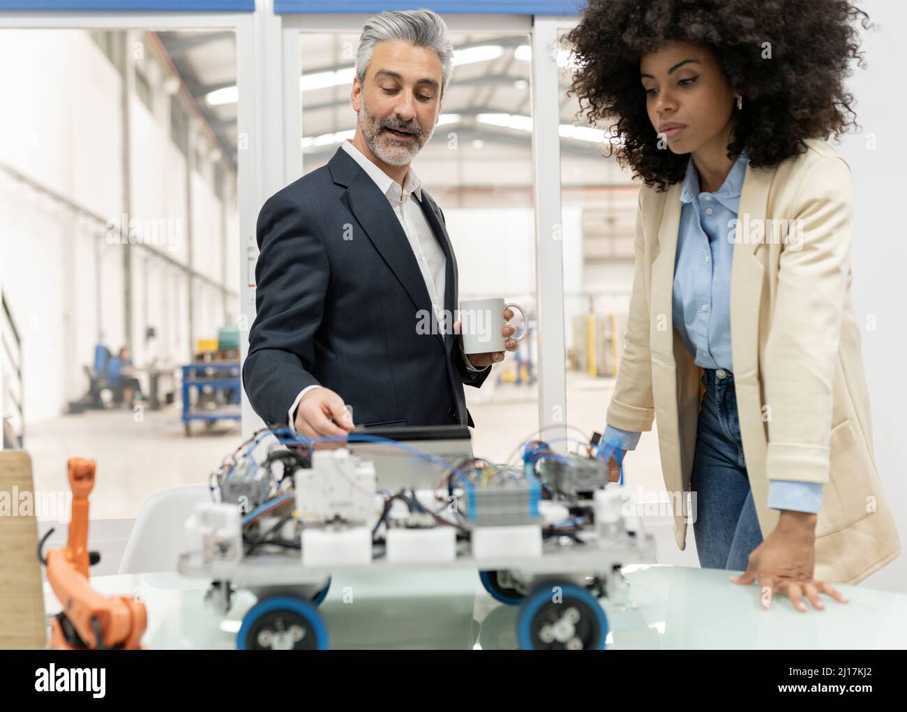 Engineer discussing about model of robotic vehicle with developer in ...
