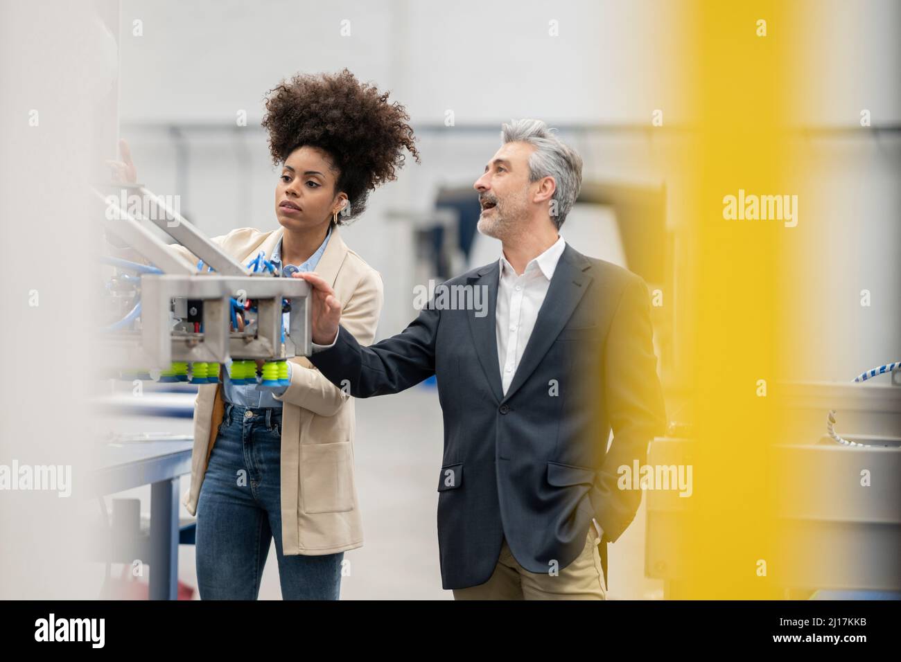 Engineers analyzing machine working together in factory Stock Photo - Alamy