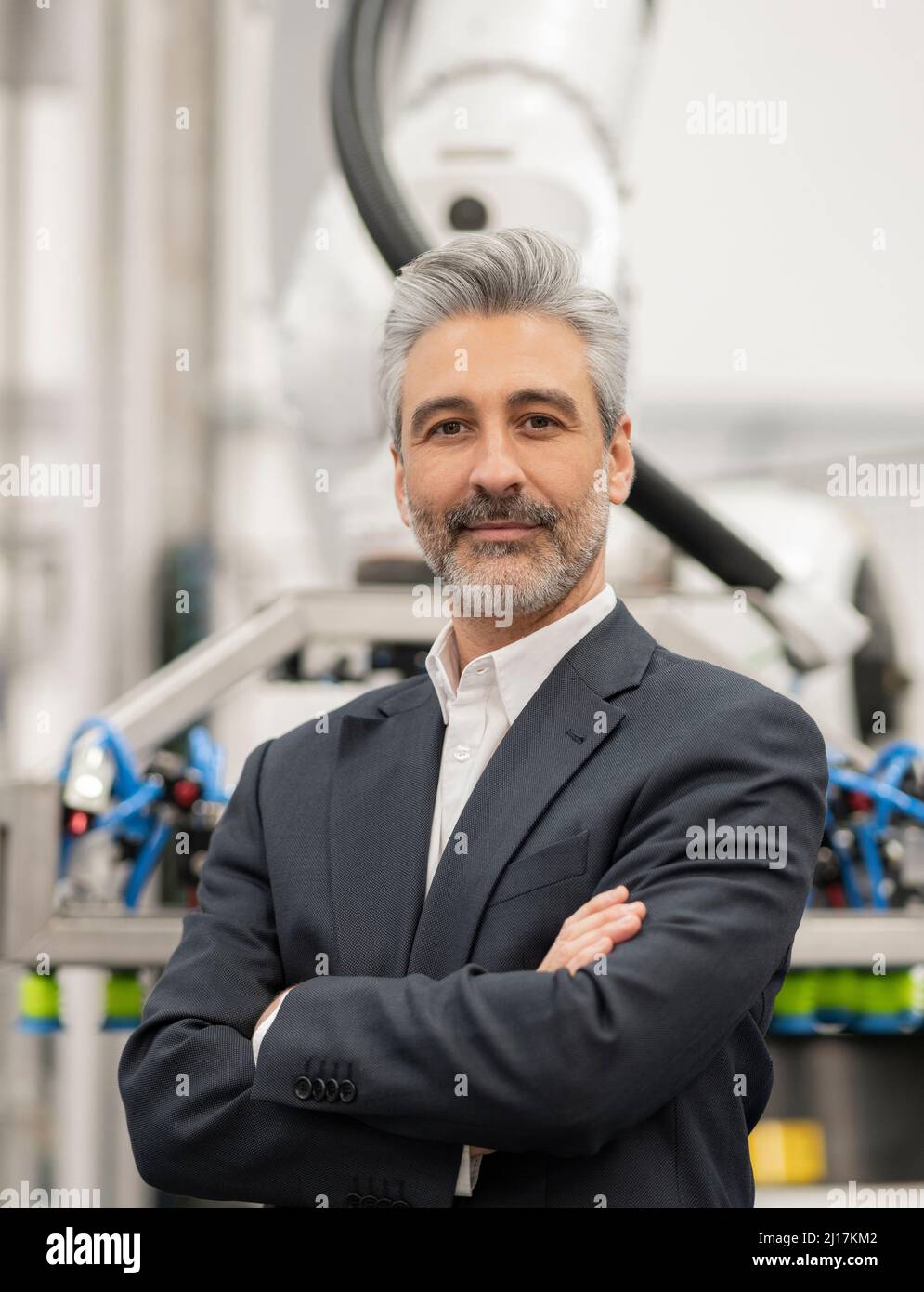 Businessman standing with arms crossed in at factory Stock Photo - Alamy