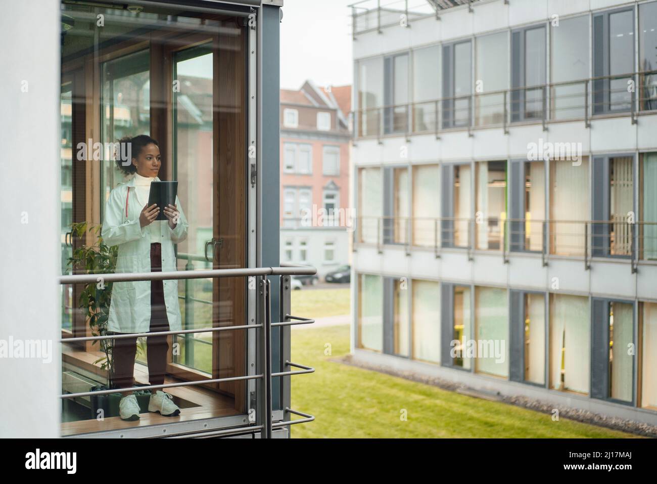 Doctor with tablet PC seen through window of hospital Stock Photo - Alamy