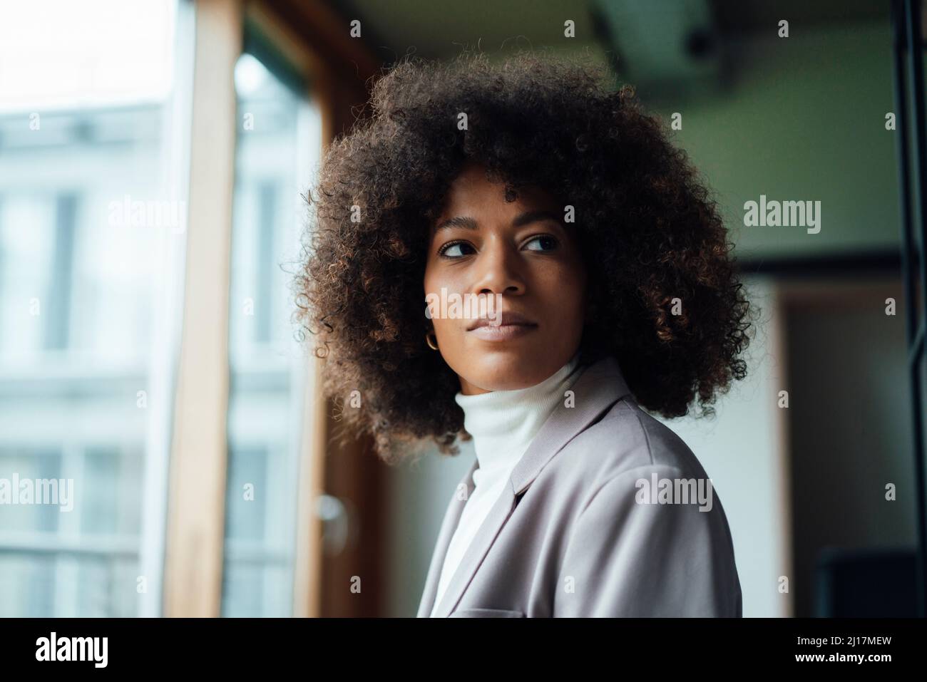 Working woman with curly hair in office Stock Photo - Alamy