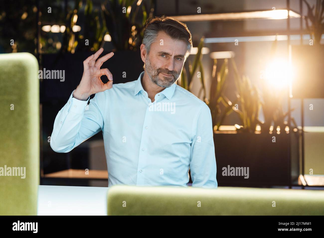 Businessman doing OK sign at work place Stock Photo - Alamy