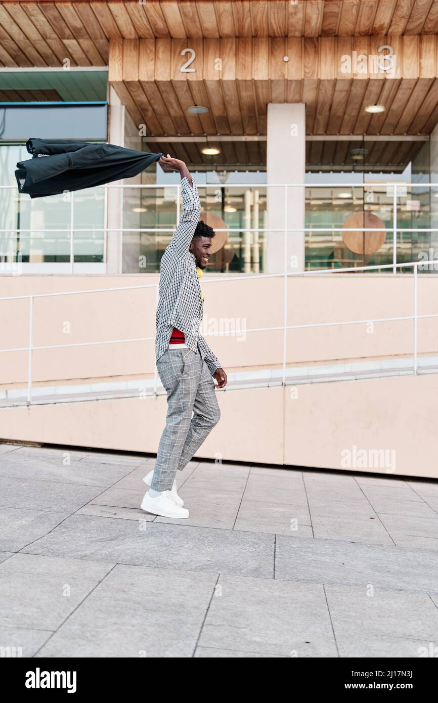 man waving his jacket over his head in celebration Stock Photo - Alamy