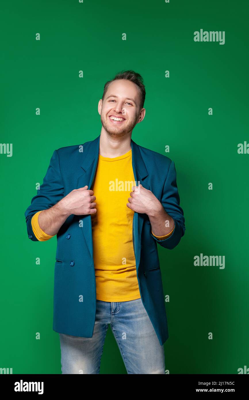 Happy man wearing blue jacket in front of green background Stock Photo ...