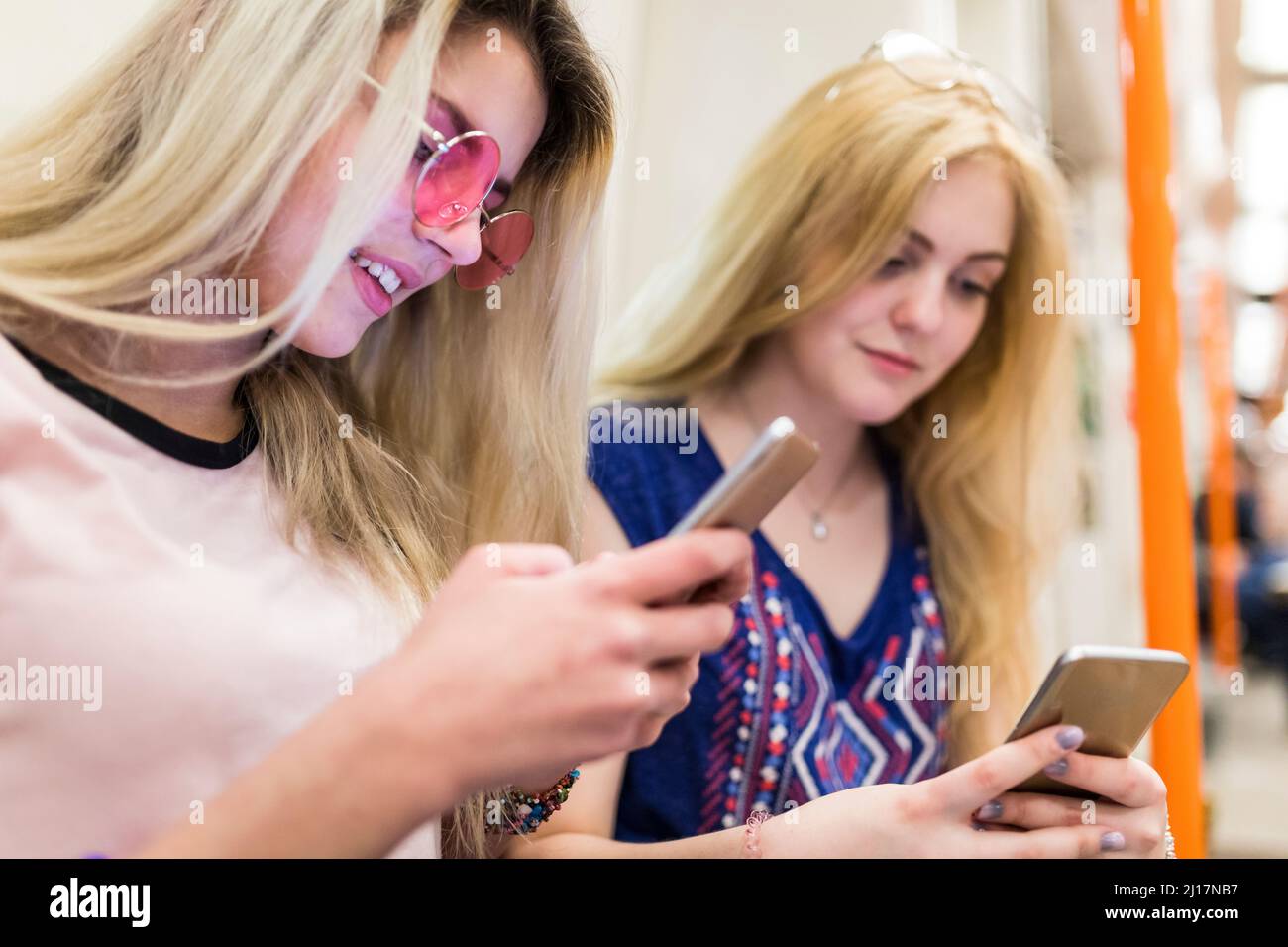 Blond teenagers surfing net through mobile phones Stock Photo - Alamy
