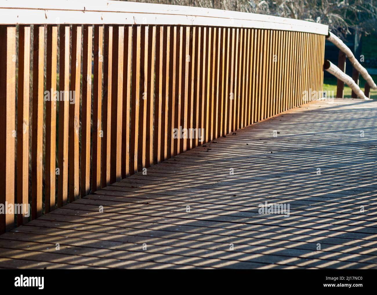 Shadows on wooden walkway with wooden railing forming boxes Stock Photo ...