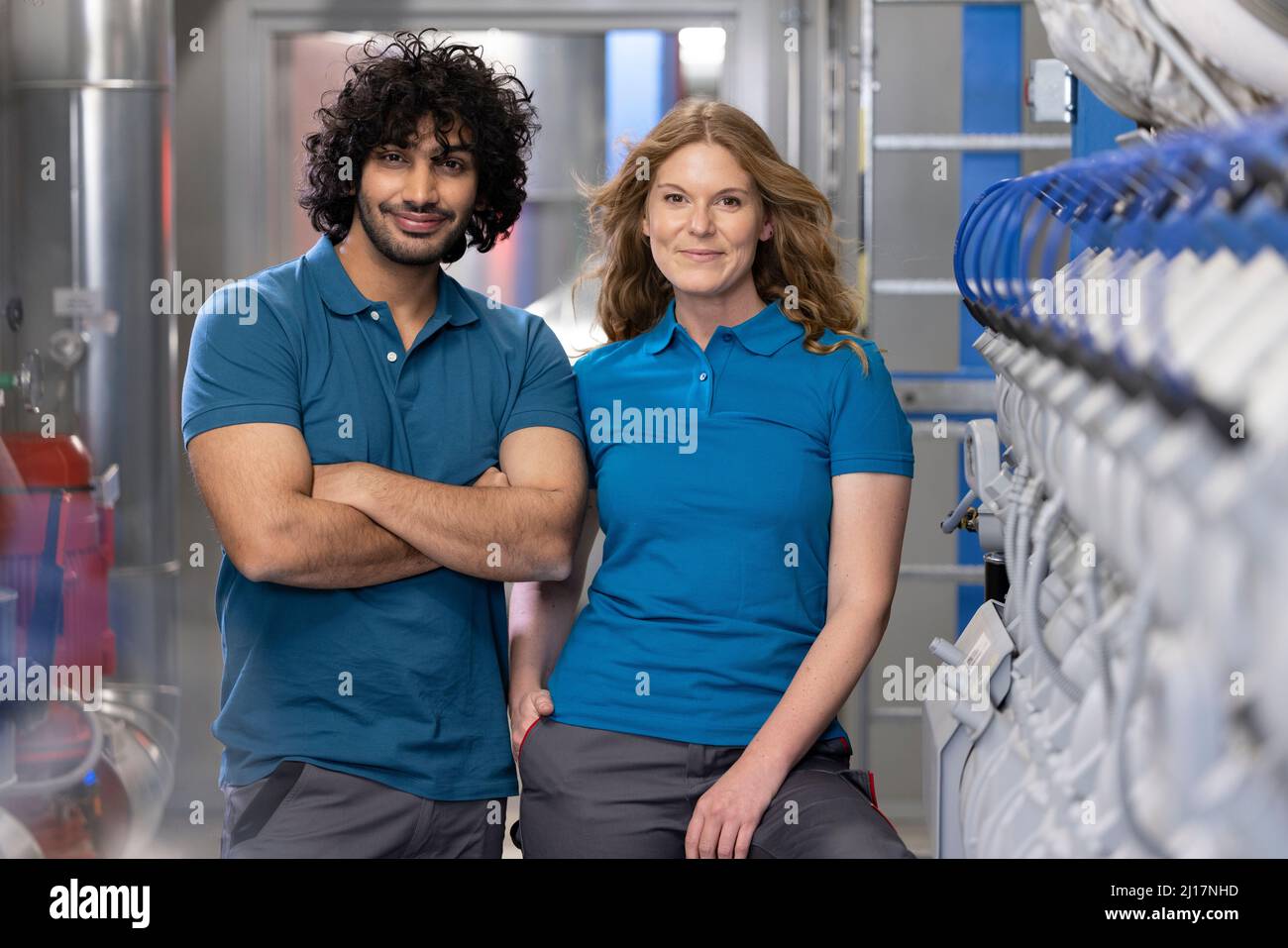 Smiling technician colleagues standing together at factory Stock Photo ...