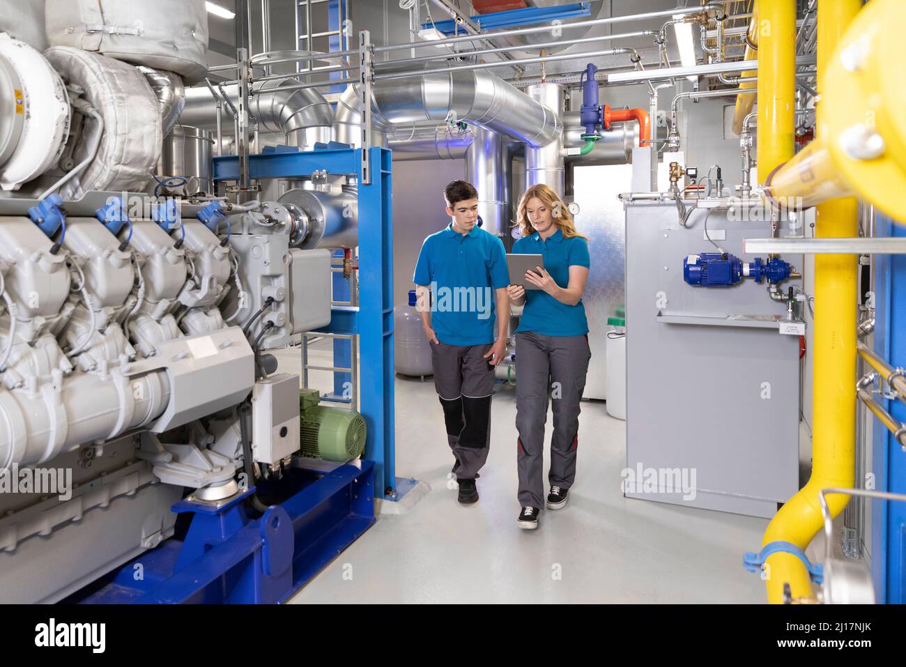 Technician showing tablet PC to trainee in factory Stock Photo - Alamy