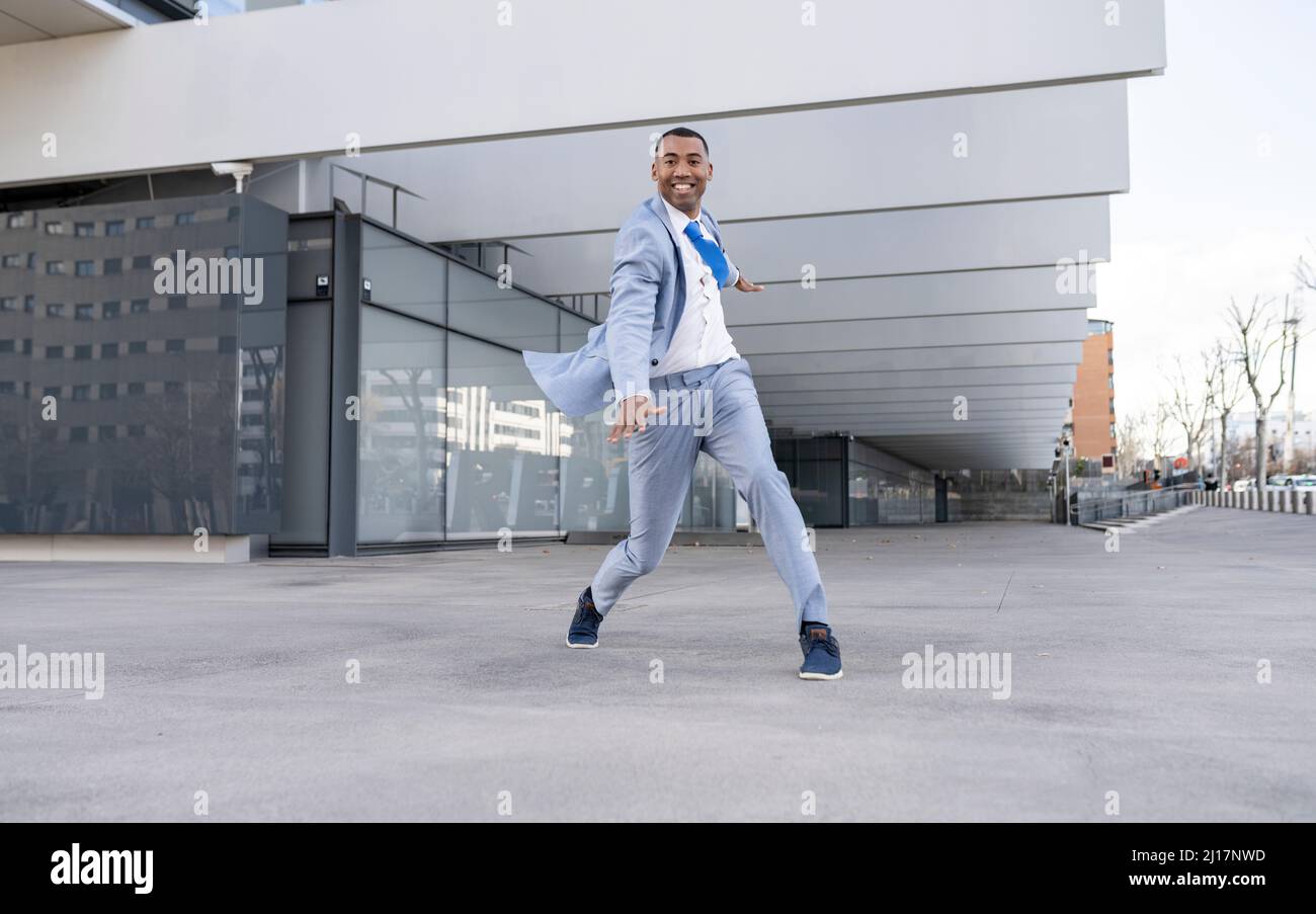 Smiling businessman dancing in front of building Stock Photo - Alamy