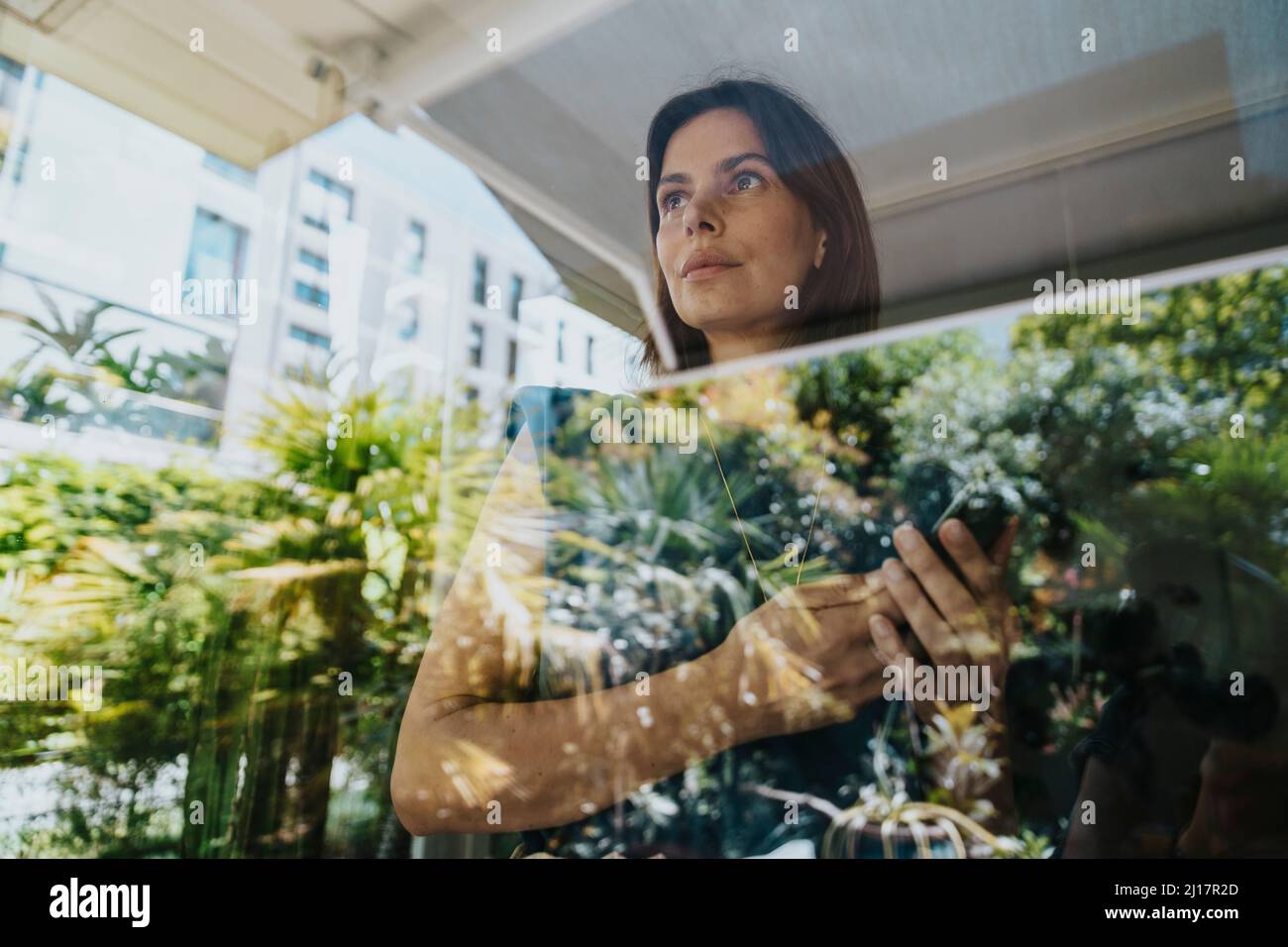 Woman seen through glass of house Stock Photo - Alamy