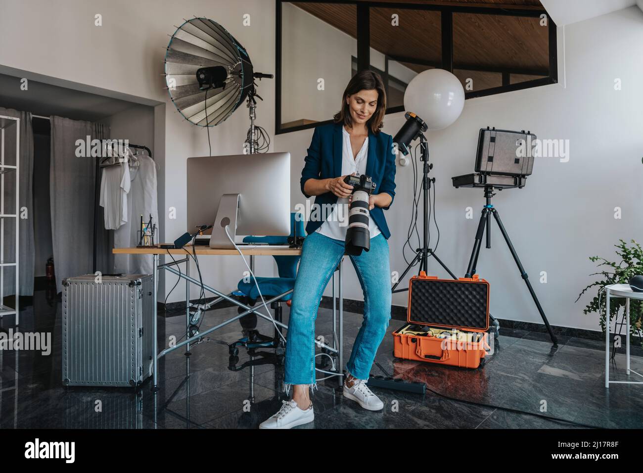 Photographer holding camera standing in studio Stock Photo - Alamy