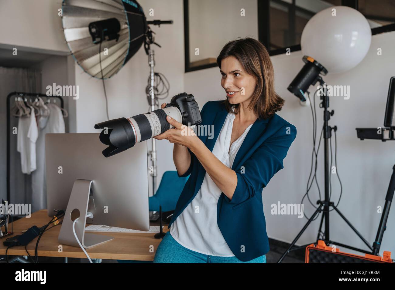 Photographer photographing through camera in studio Stock Photo - Alamy