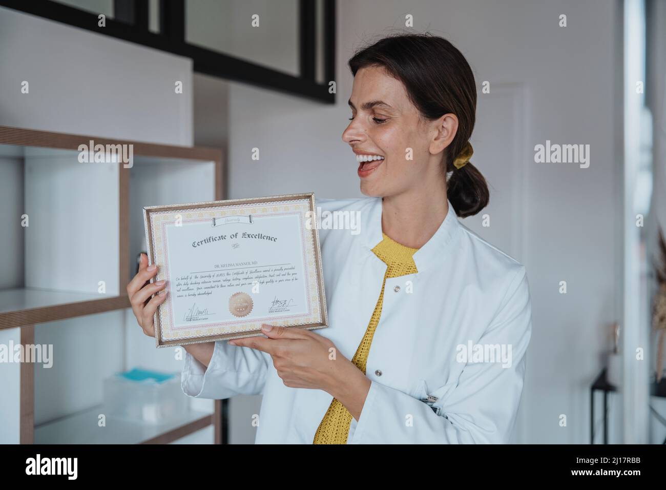 Happy female doctor holding certificate in clinic Stock Photo - Alamy