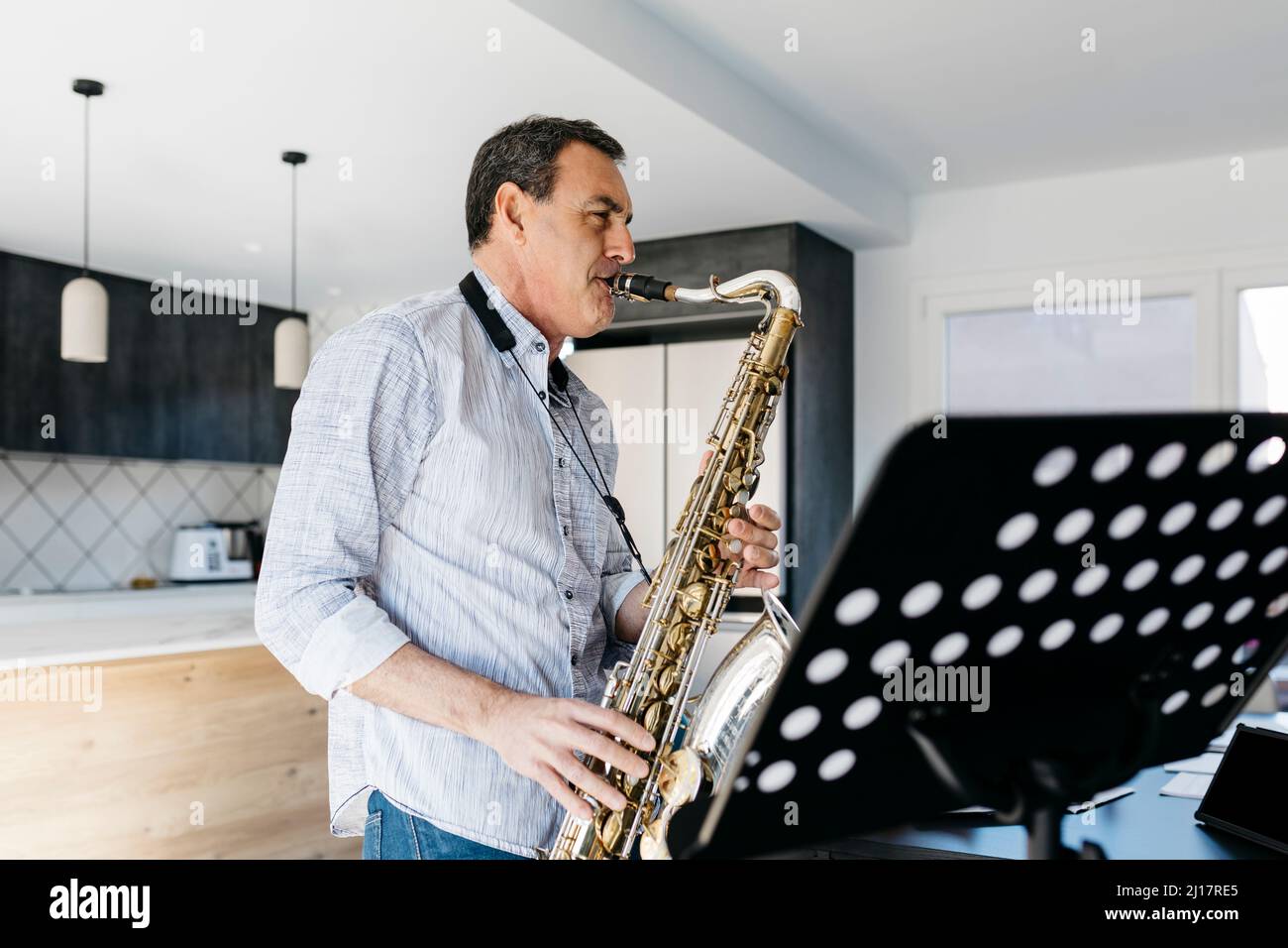 Musician blowing saxophone practicing at home Stock Photo - Alamy